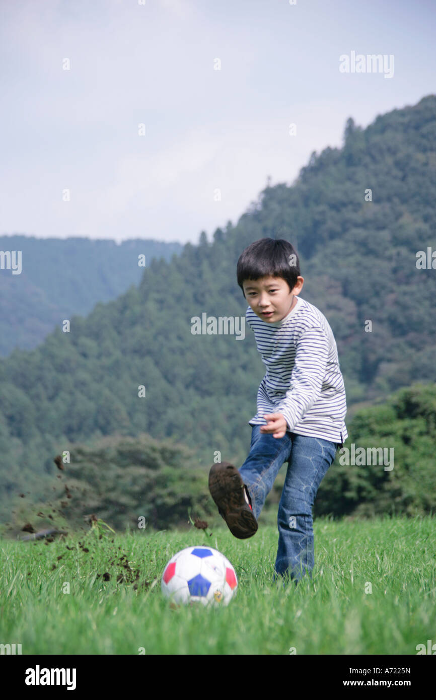 Boy kicking soccer ball Stock Photo - Alamy