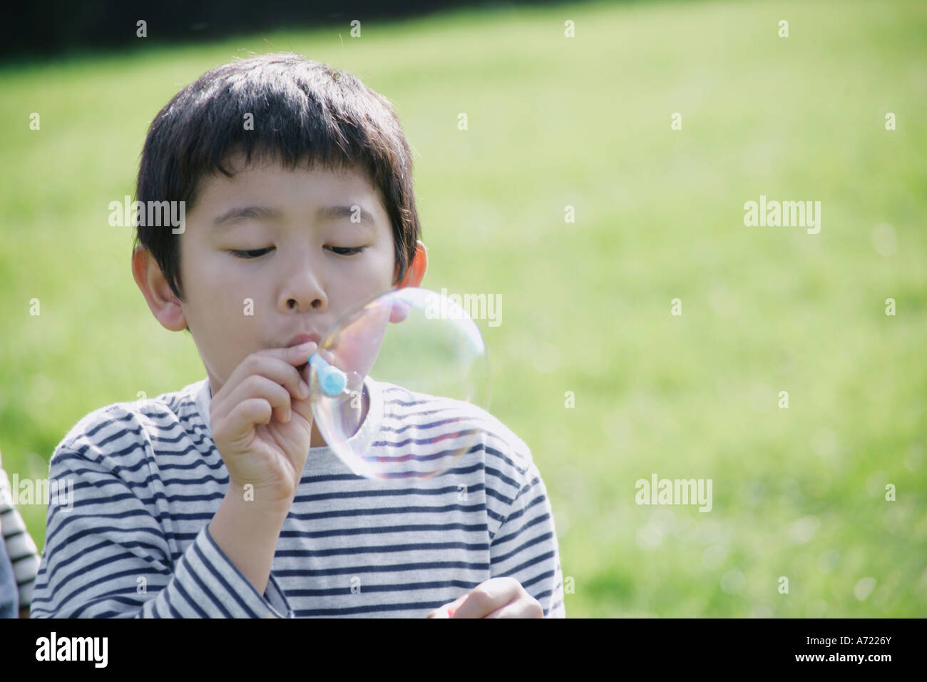 Boy blowing bubbles Stock Photo - Alamy
