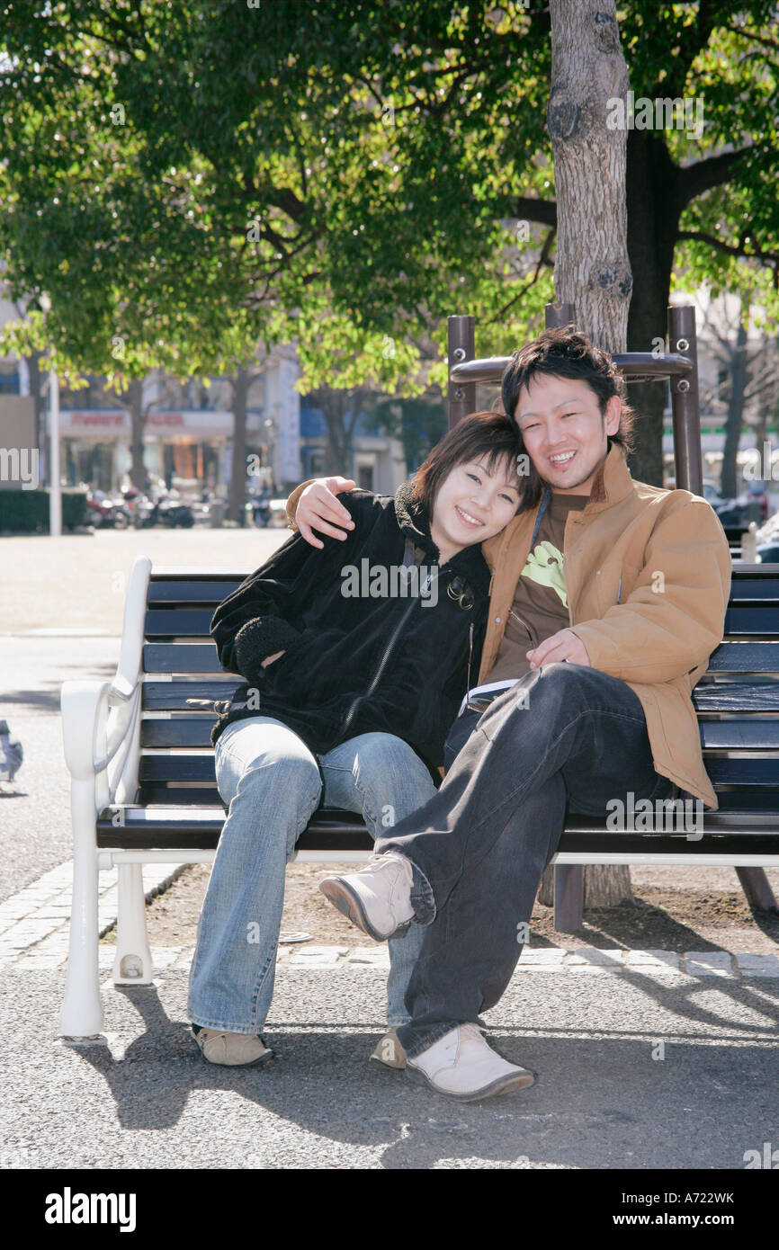 Portrait of young couple sitting Stock Photo - Alamy