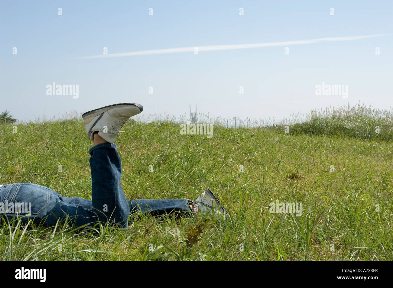 Young man lying down on field Stock Photo - Alamy