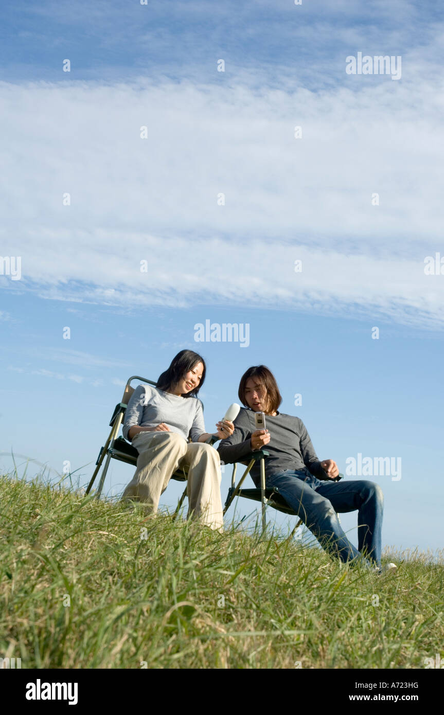 Young couple sitting in chairs Stock Photo - Alamy