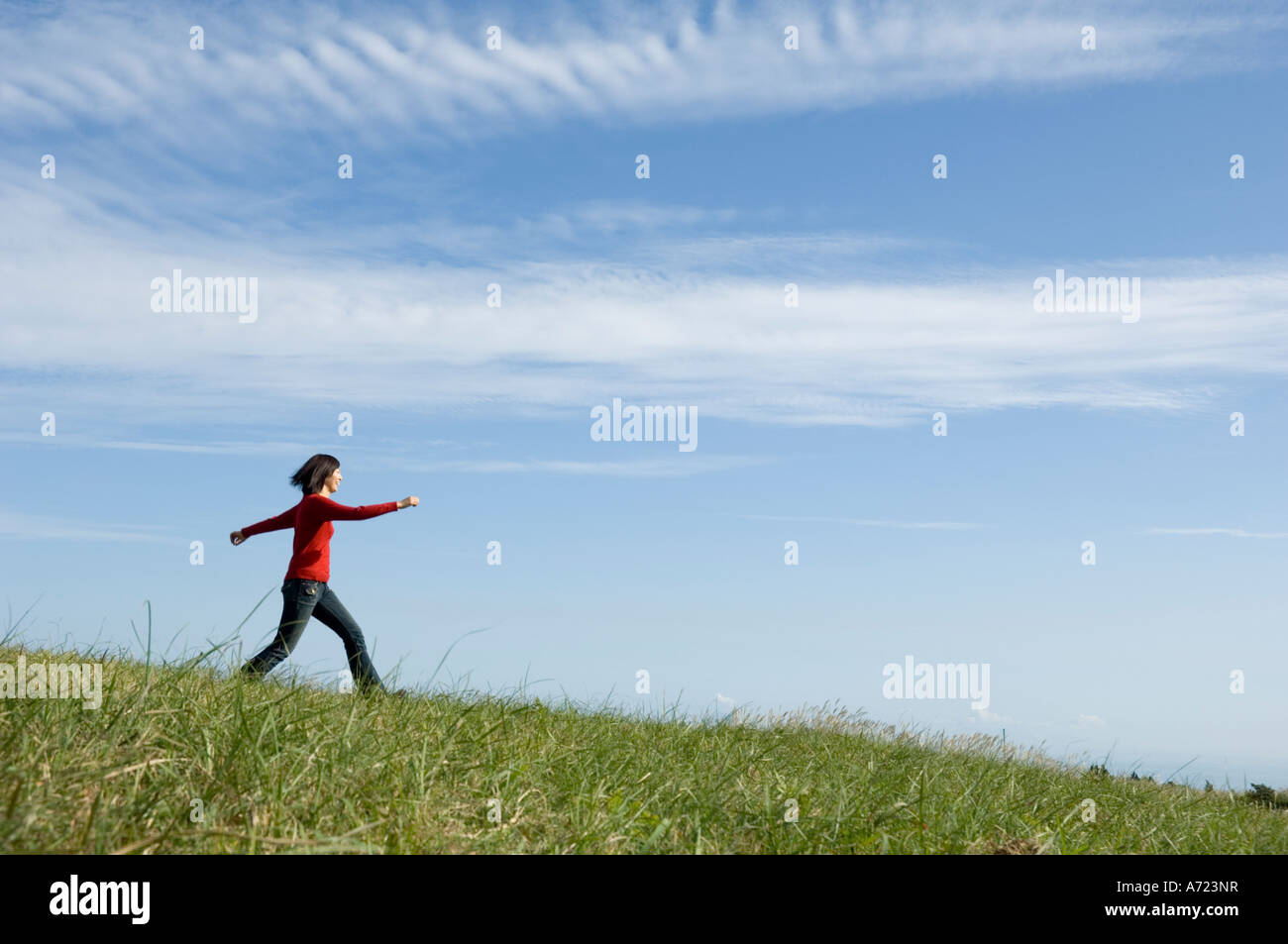 Young woman skipping in field Stock Photo - Alamy