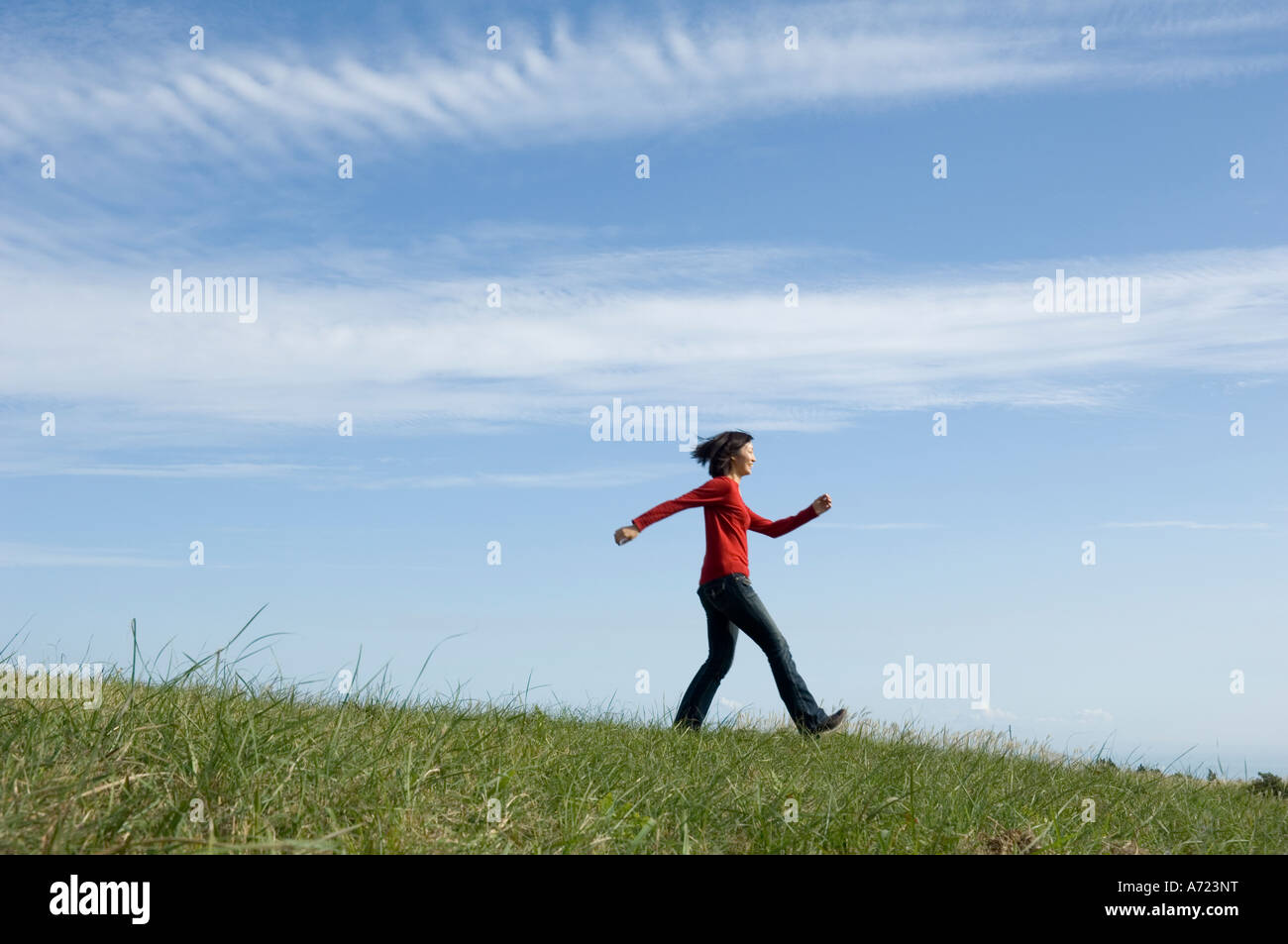Young woman skipping in field Stock Photo - Alamy