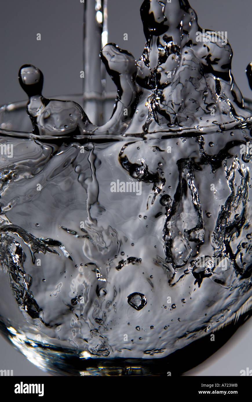 Liquid splashing into wine glass action shot Stock Photo - Alamy