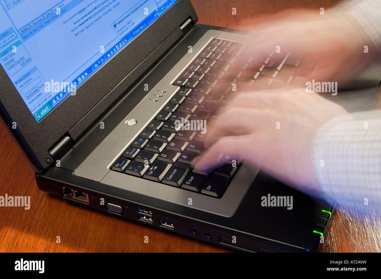 Blurred hands - suggesting movement - typing on a laptop computer ...
