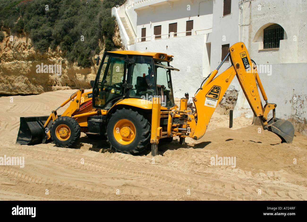 Mechanical JCB digger moving sand Stock Photo - Alamy