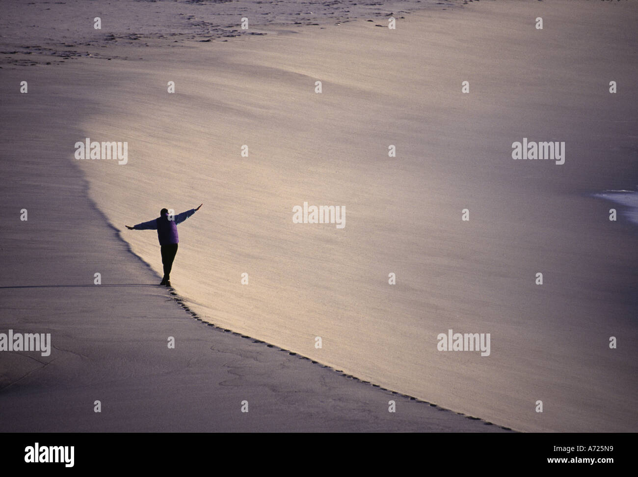 Woman balancing on tide line on sand Barra Western Isles Scotland Stock ...