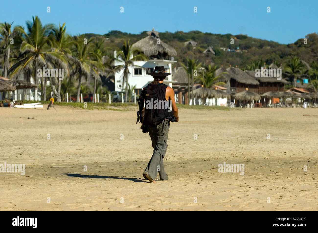 Zipolite - man with a backpack walk on the beach - Mexico Stock Photo ...