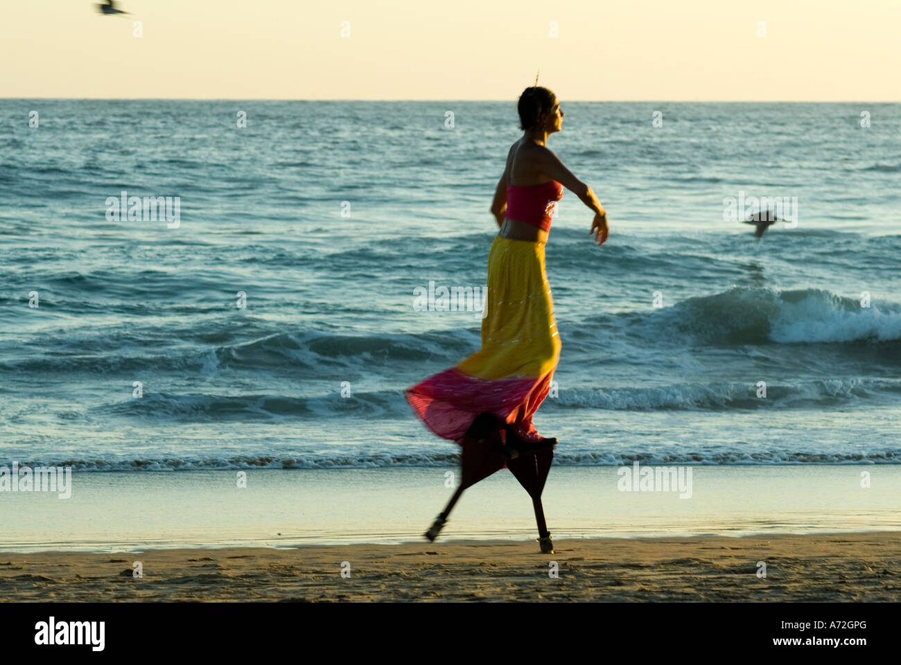 Zipolite sunset - woman on stilts walk and dance on the sand - Oaxaca ...