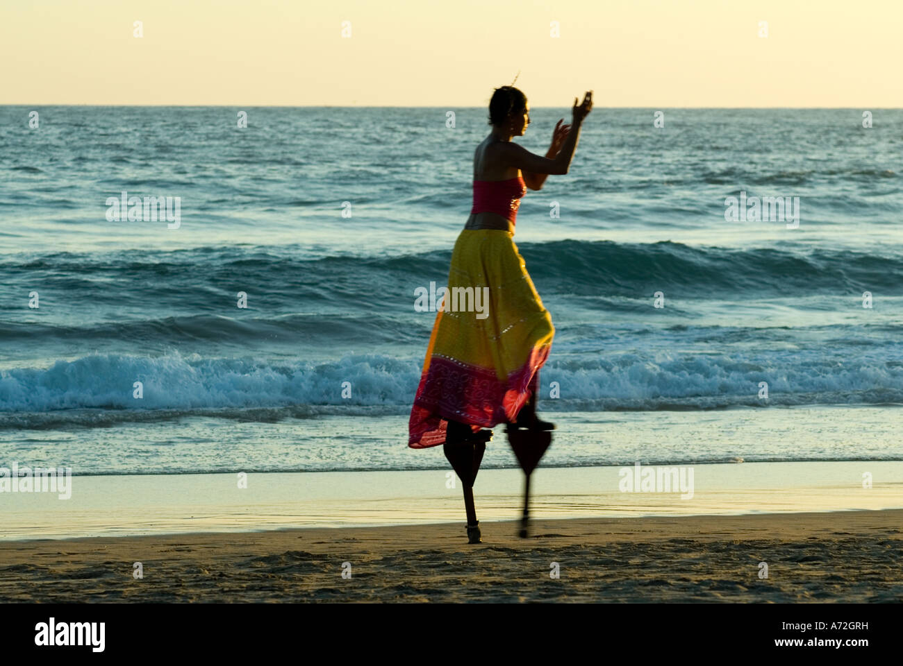 Zipolite sunset - woman on stilts walk and dance on the sand - Oaxaca ...