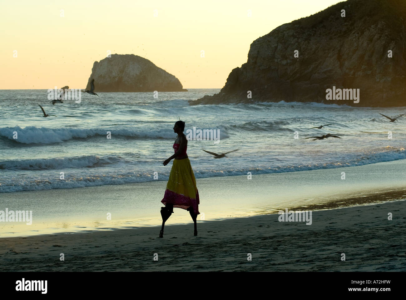 Zipolite sunset - woman on stilts walk on the sand - Oaxaca - Mexico ...
