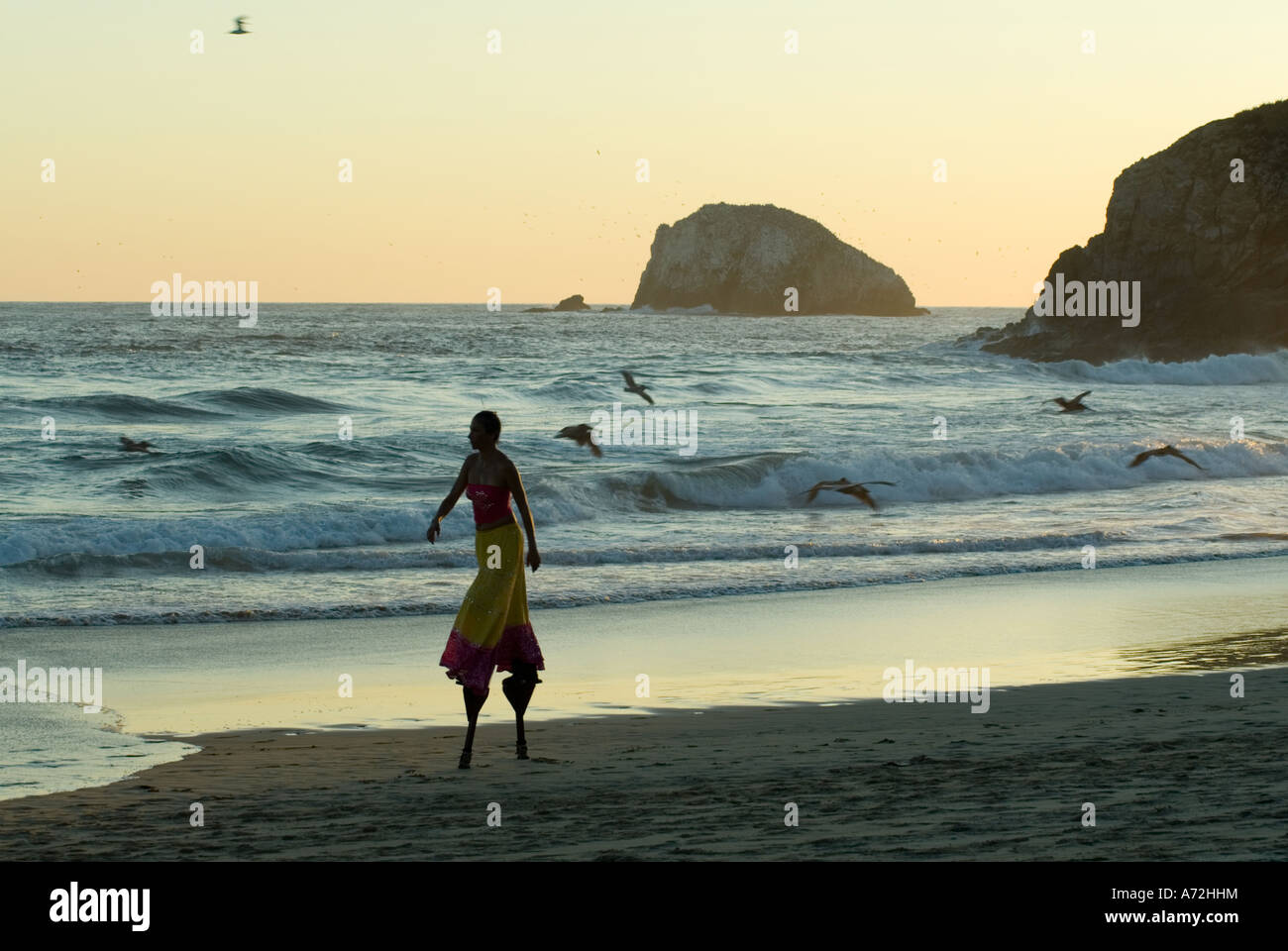 Zipolite sunset - woman on stilts walk on the sand - Oaxaca - Mexico ...
