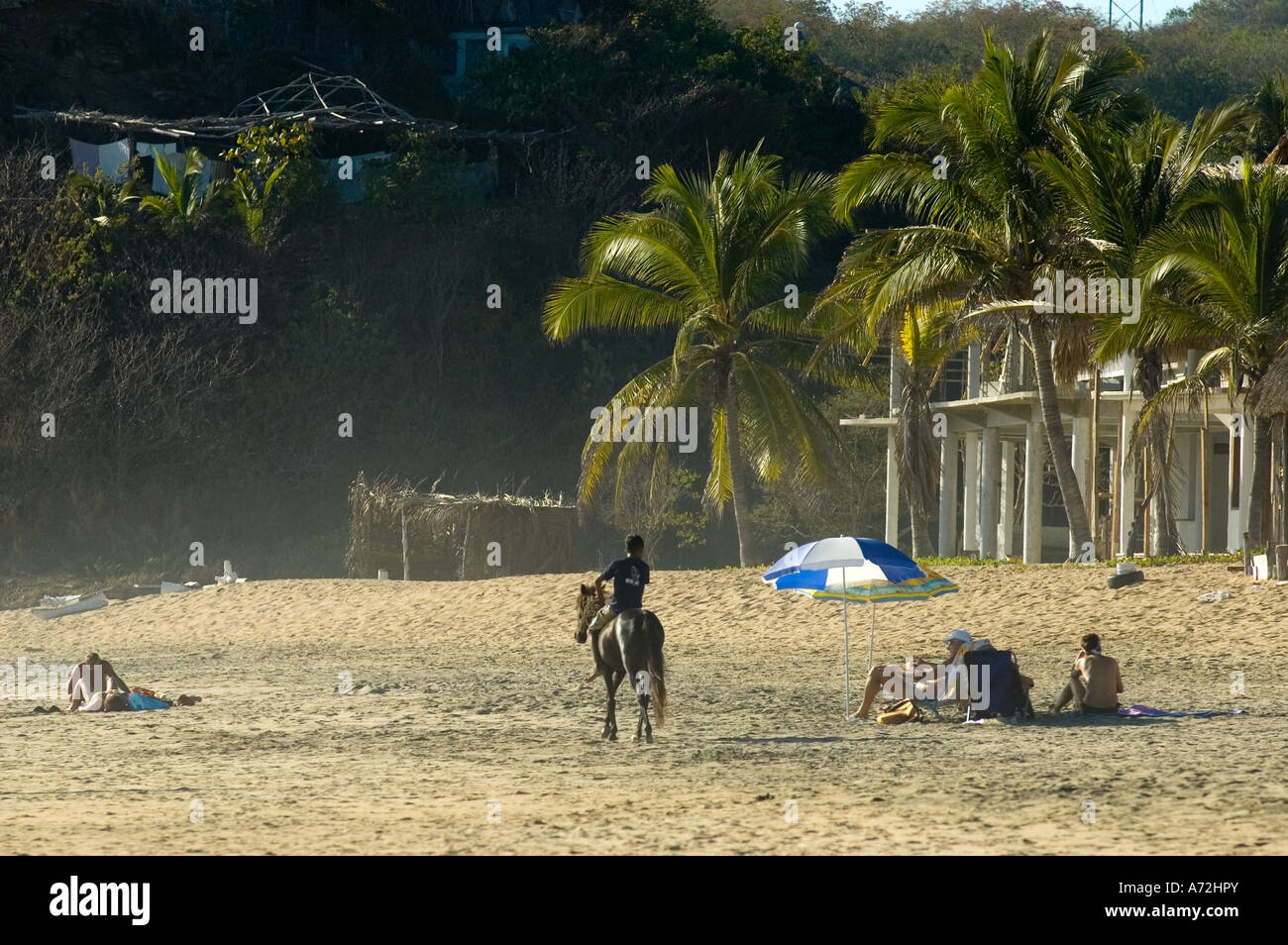Zipolite - people on the beach and a man on a horse - Mexico Stock ...