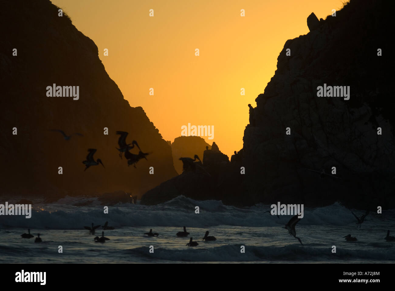 Zipolite - sunset between the rocks and three men in the background ...
