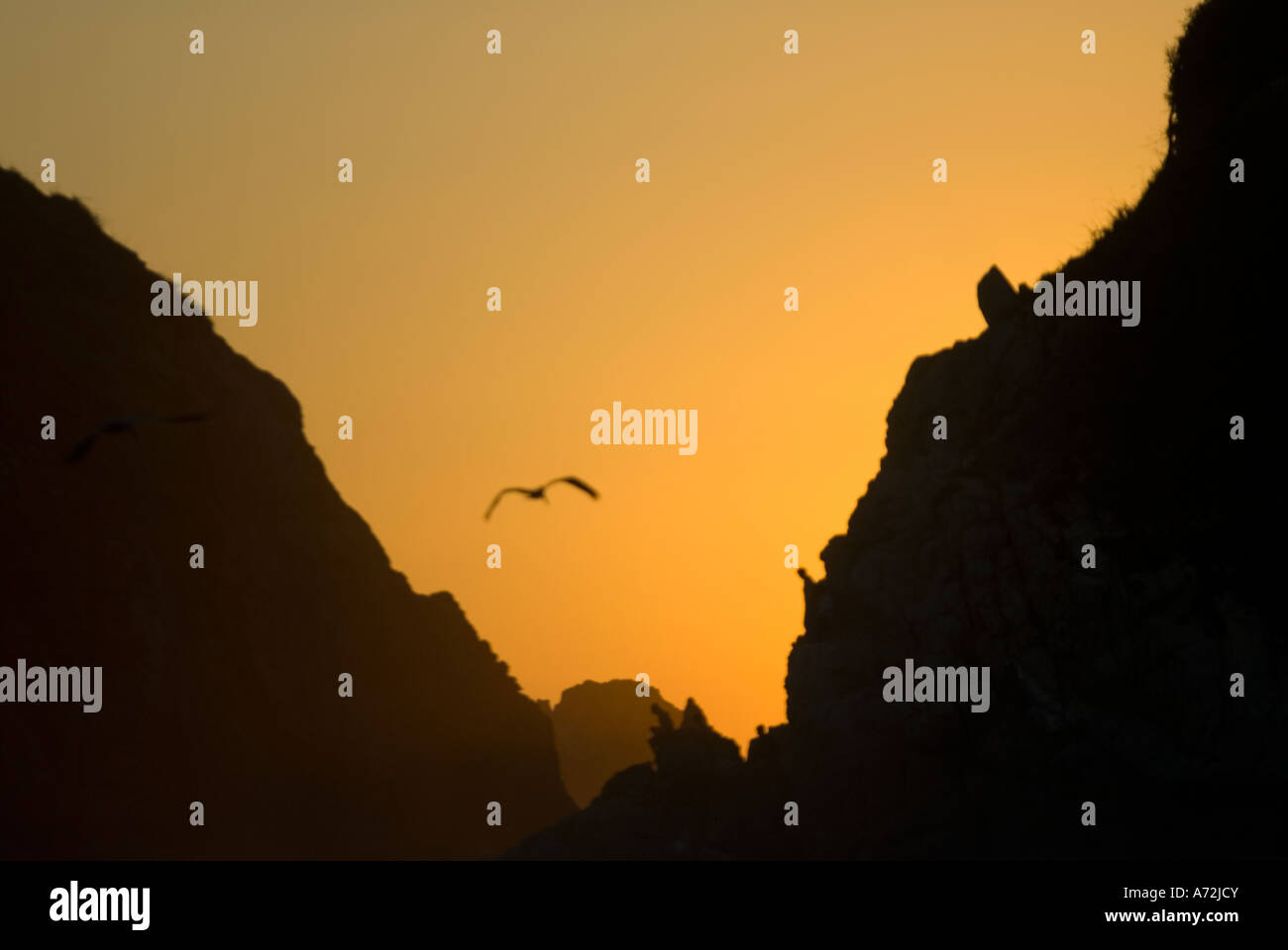 Zipolite - sunset between the rocks and three men in the background ...