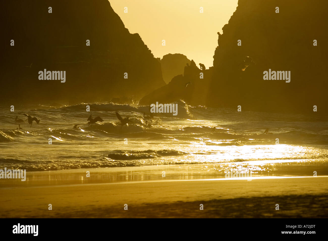 Zipolite - sunset between the rocks and three men in the background ...