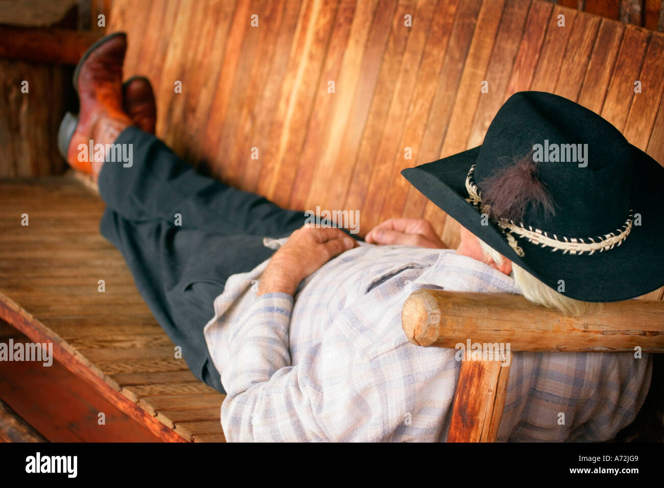 Cowboy resting on a bench Stock Photo - Alamy