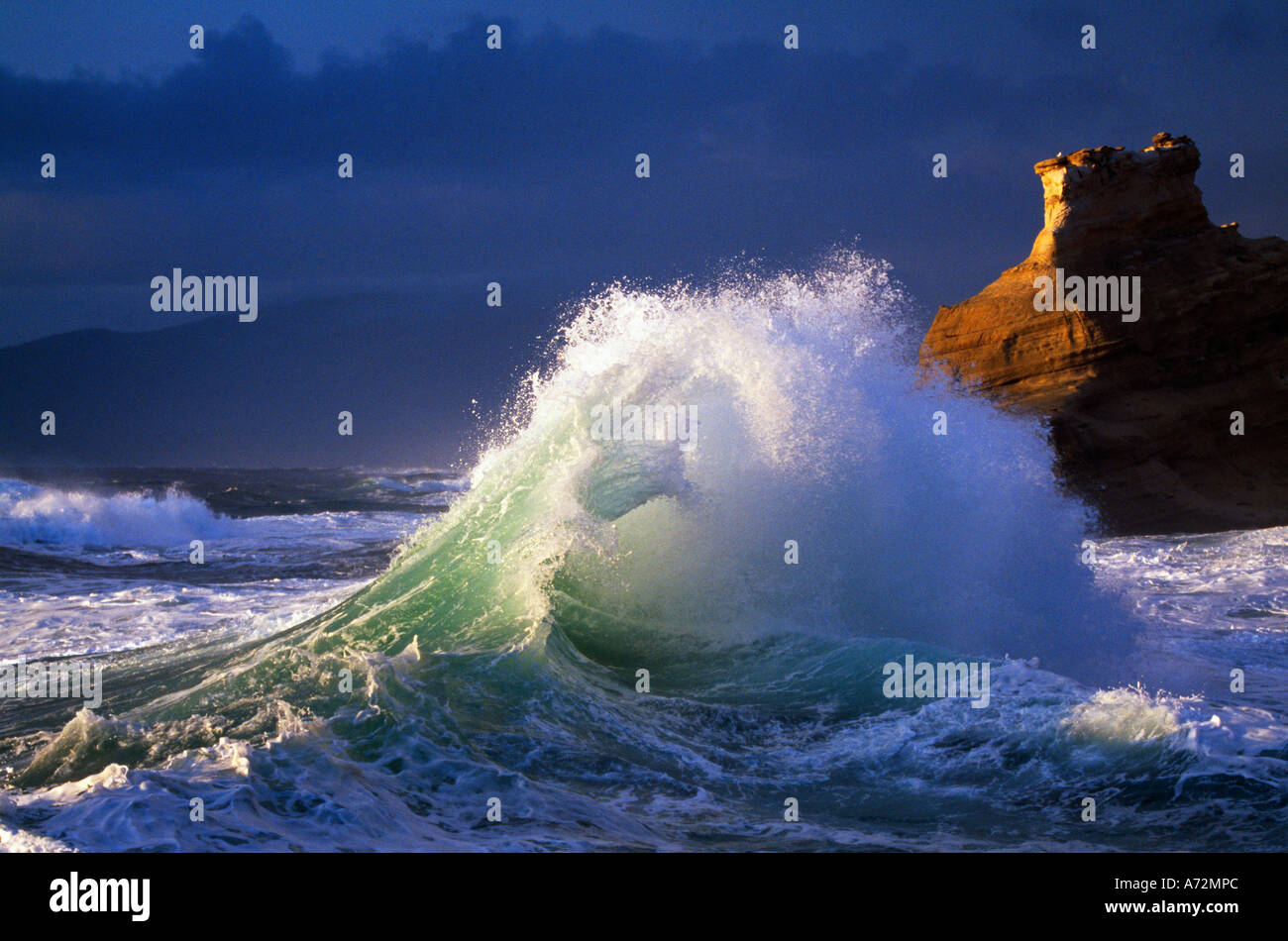 Wave crashing, distant storm, rock cliffs of Cape Kiwanda Stock Photo ...
