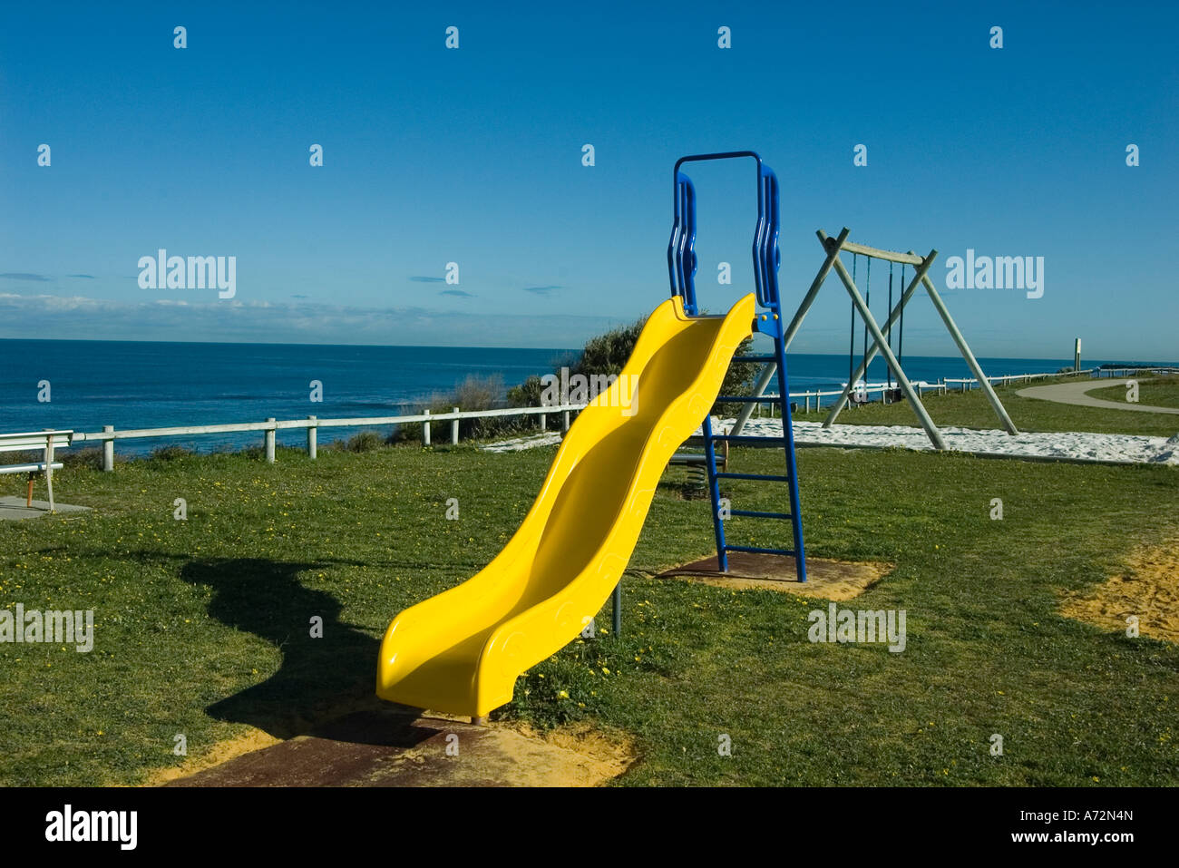 Yellow and blue slide in childrens playground Stock Photo - Alamy