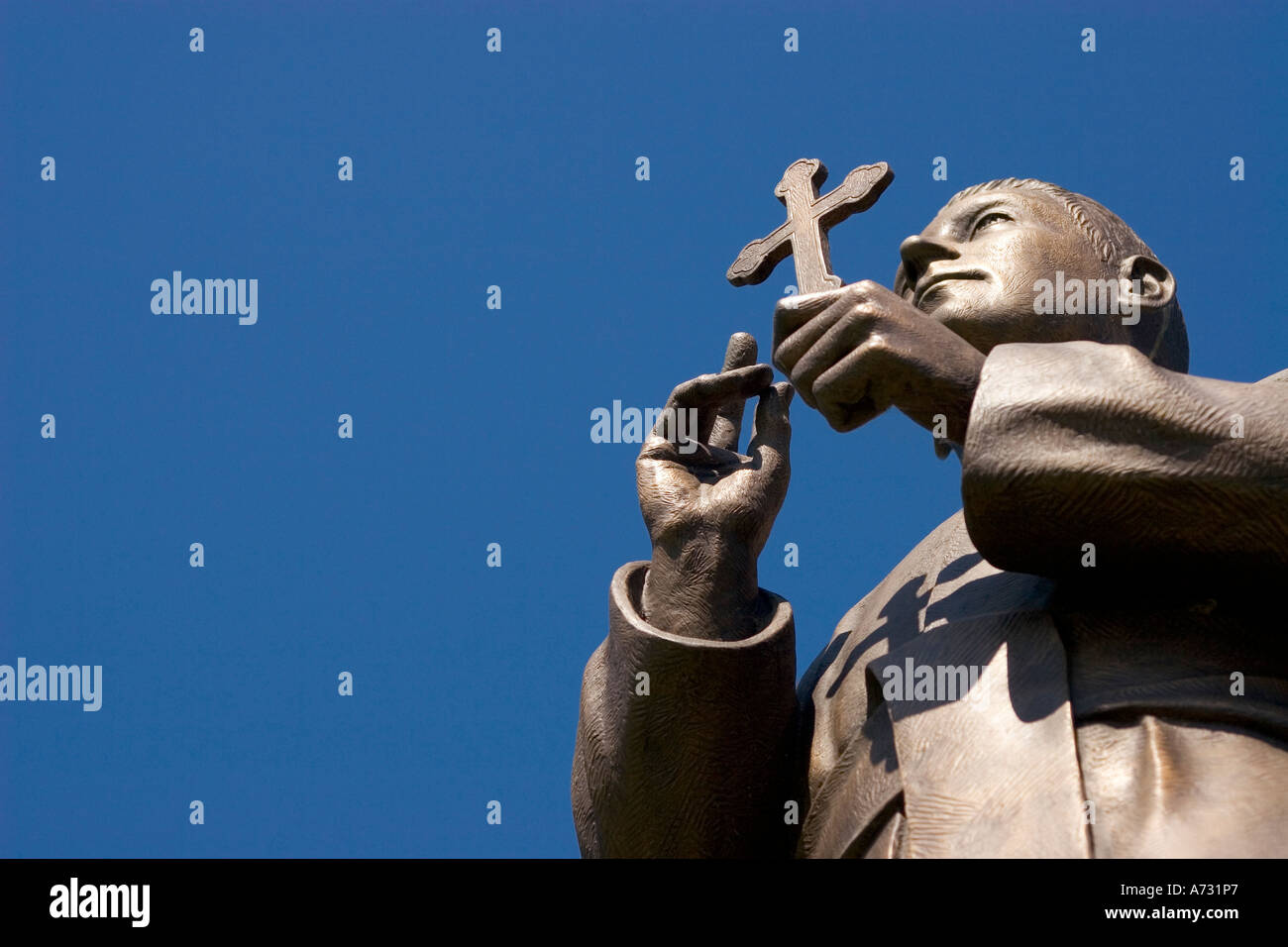 Statue holding a cross Stock Photo - Alamy