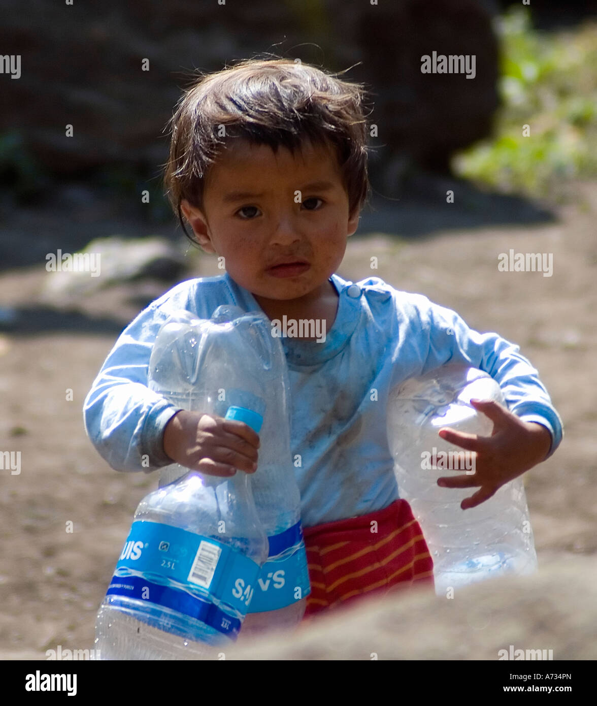 A Peruvian child carrying bottles of water. Peru Stock Photo - Alamy