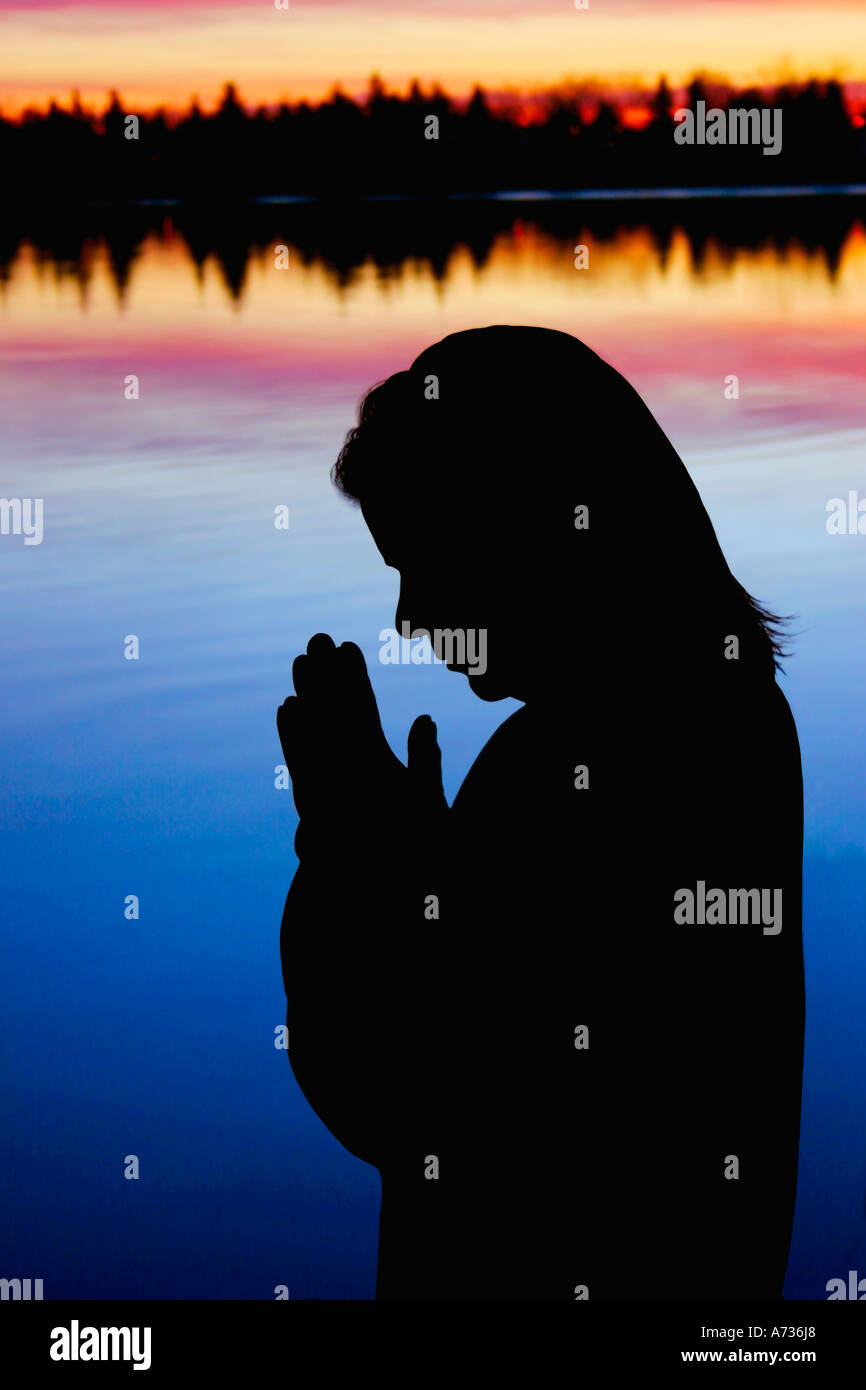 Woman praying near water Stock Photo - Alamy