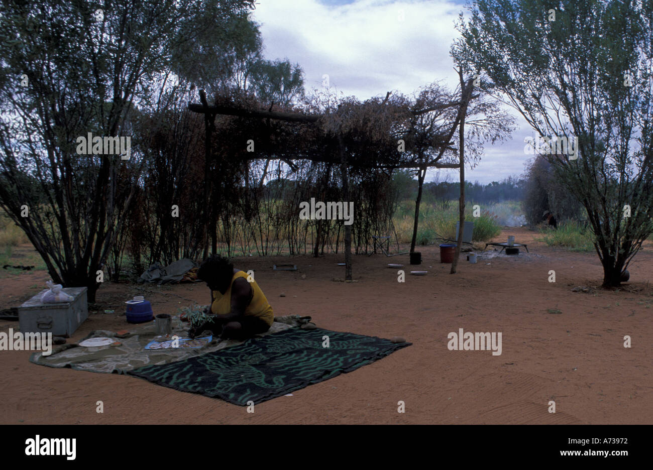 An aborigine artist from Anmatyerre tribe Central Australia painting ...