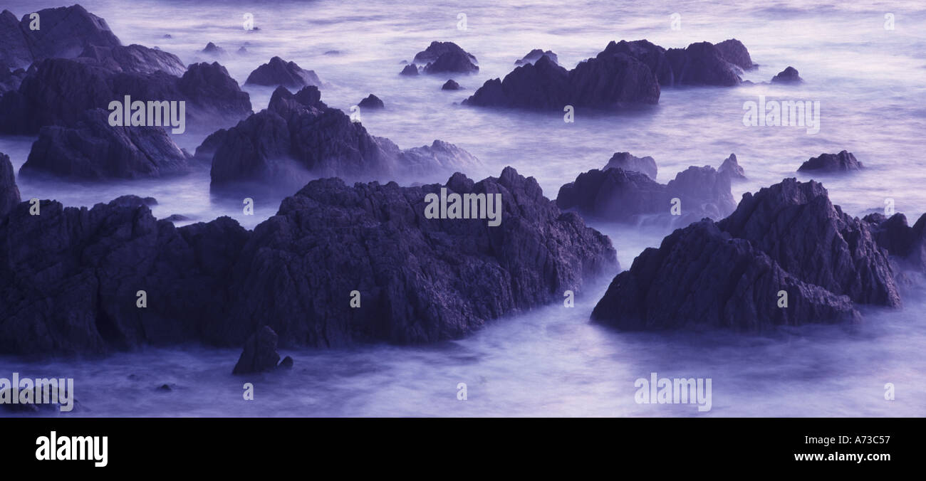 The sea washes around shoreline rocks at Rockham Bay near Woolacombe ...