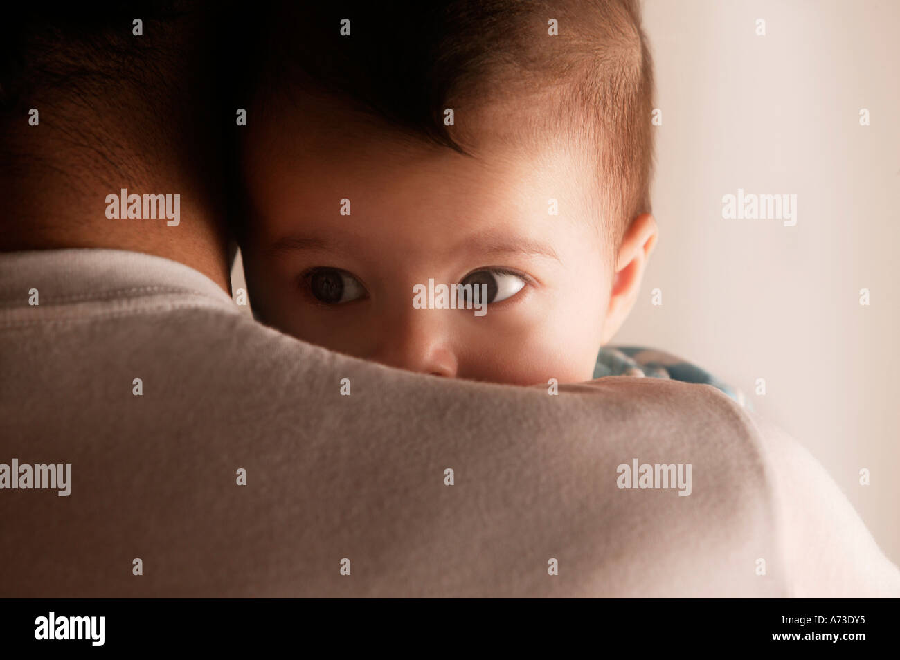 Baby peering over dads shoulder Stock Photo - Alamy