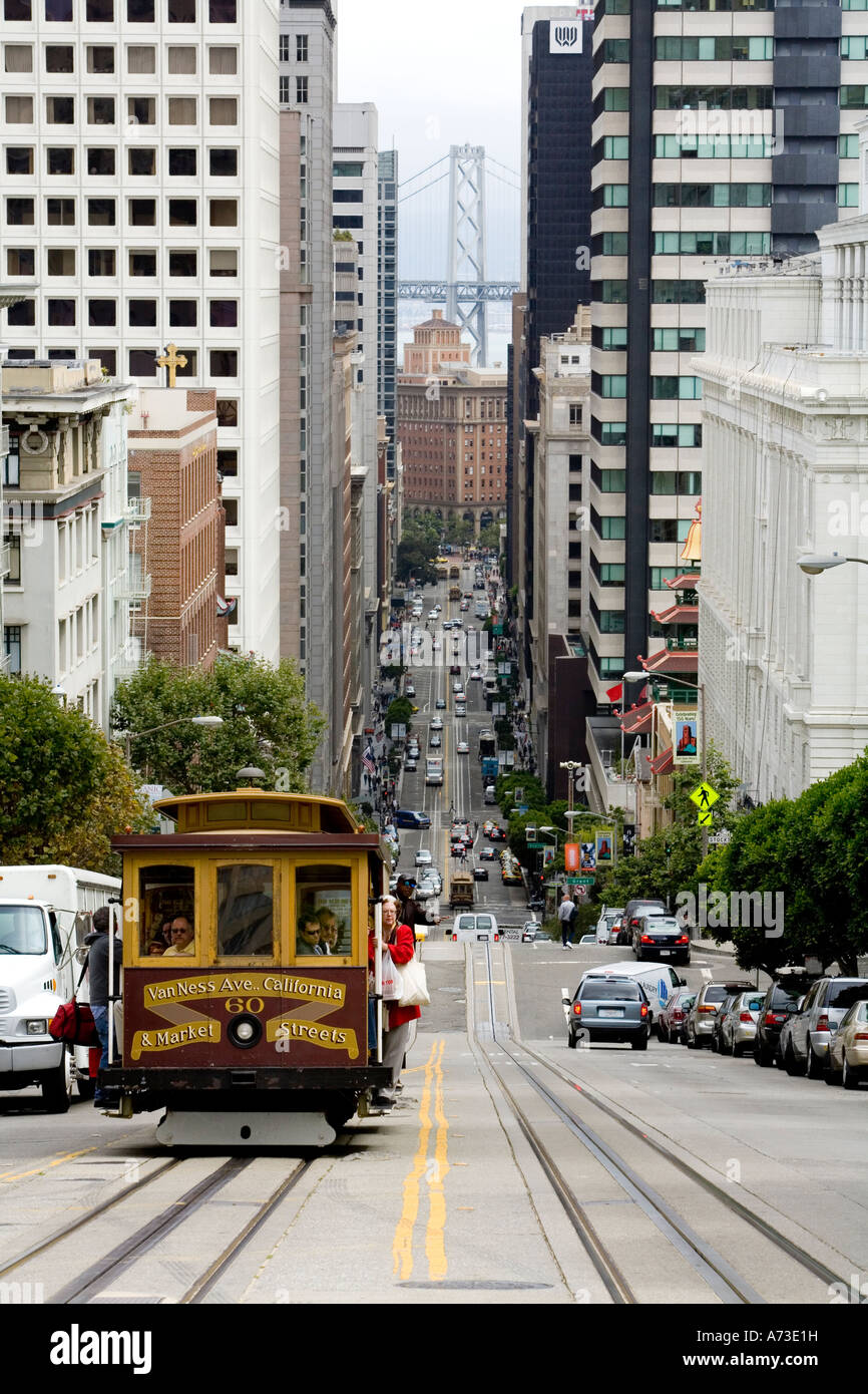 Tram driving along California Street with the Oakland Bay Bridge behind ...