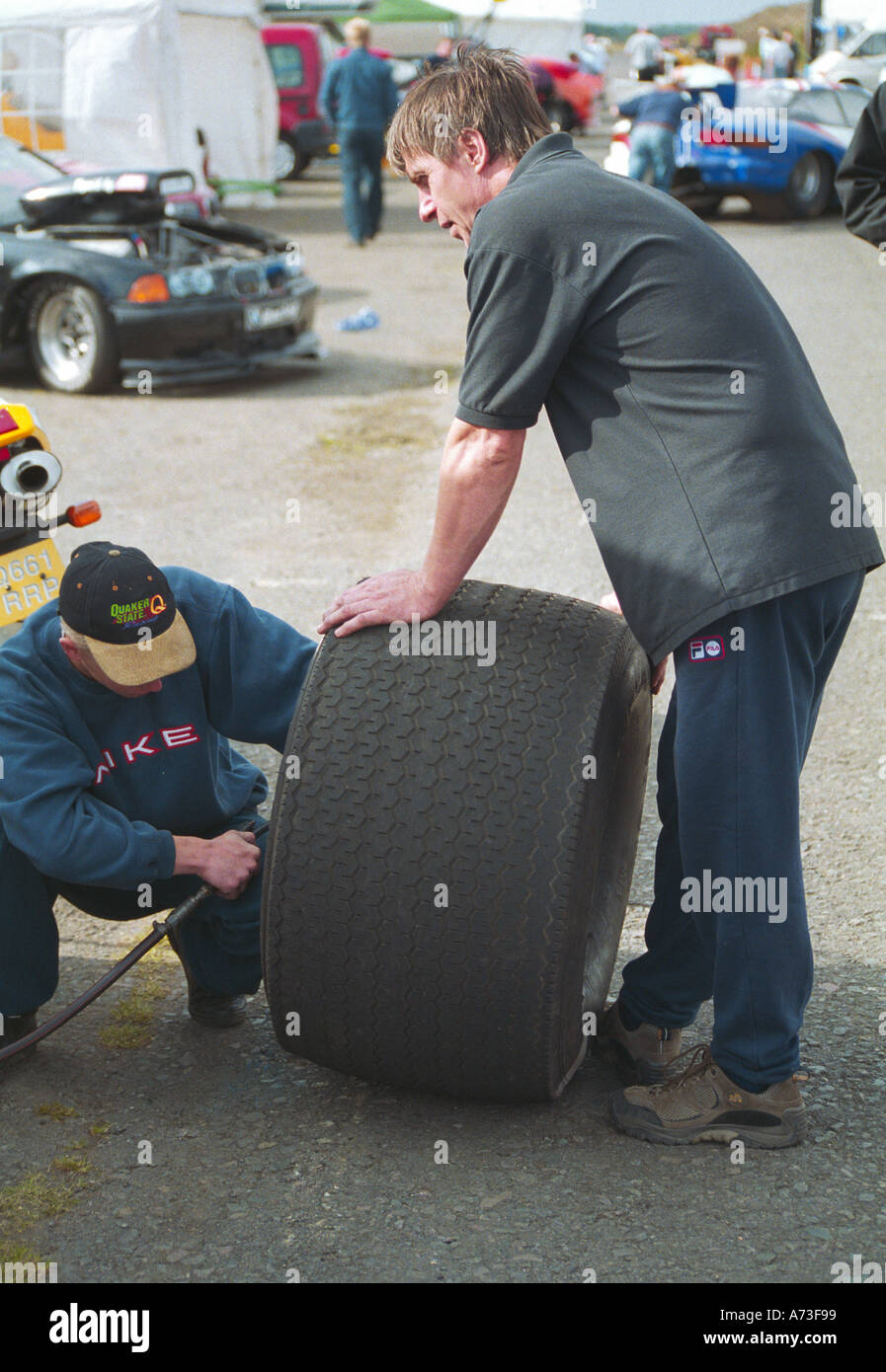huge drag racing tire being mounted on rim Stock Photo - Alamy