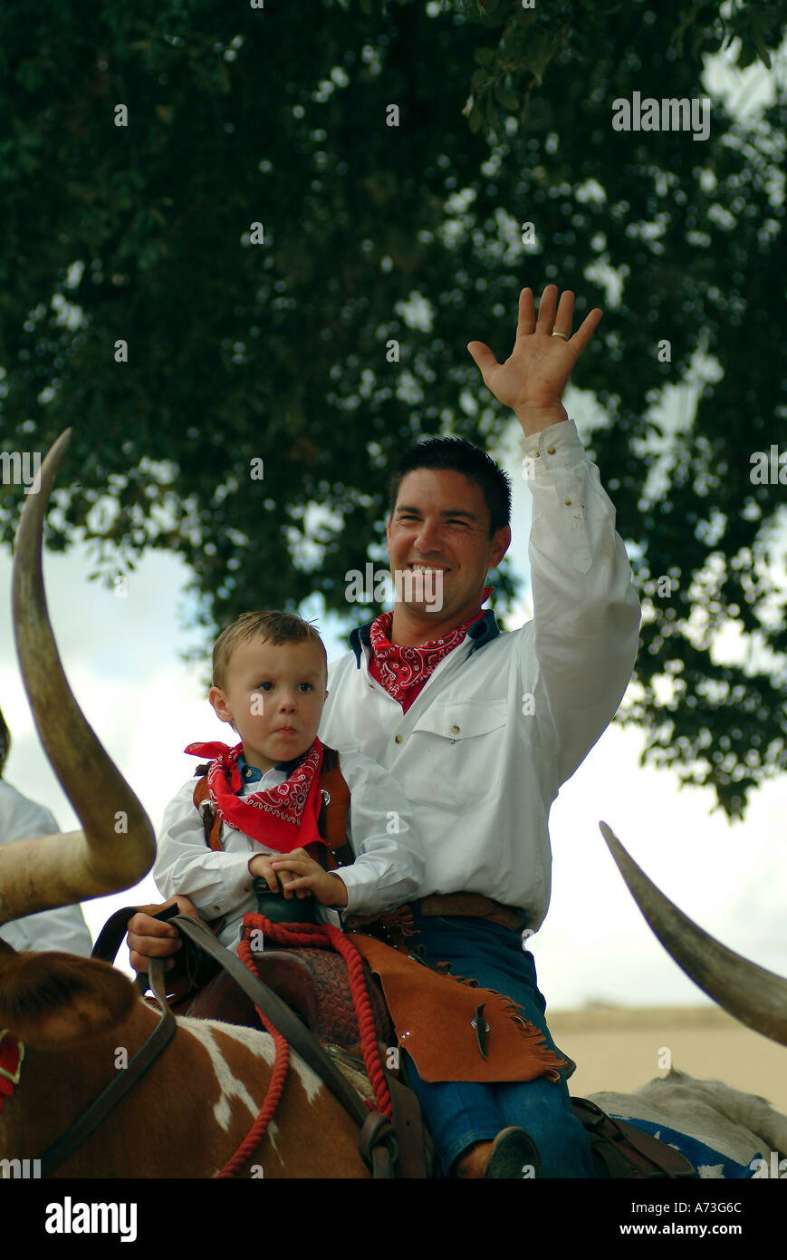 A man and his boy riding a longhorn in Bandera Texas Stock Photo - Alamy