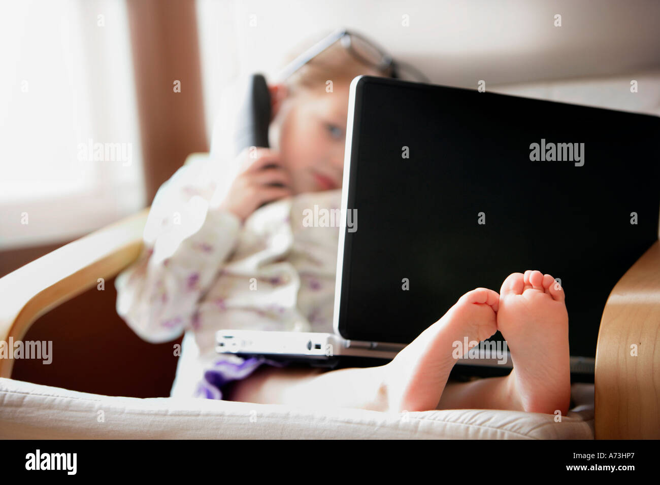 Child working on phone and computer Stock Photo - Alamy