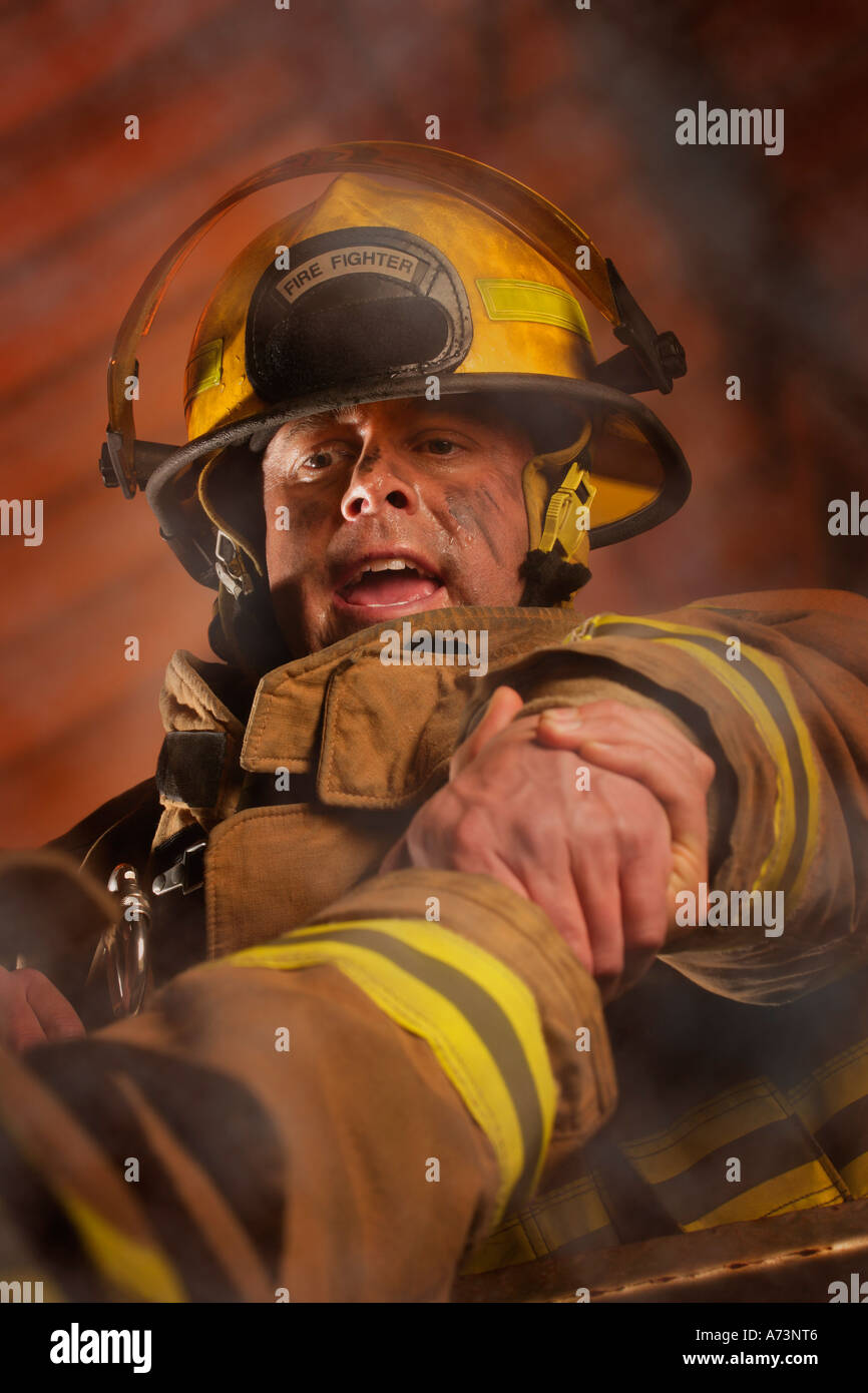 Firefighter helping another Stock Photo - Alamy