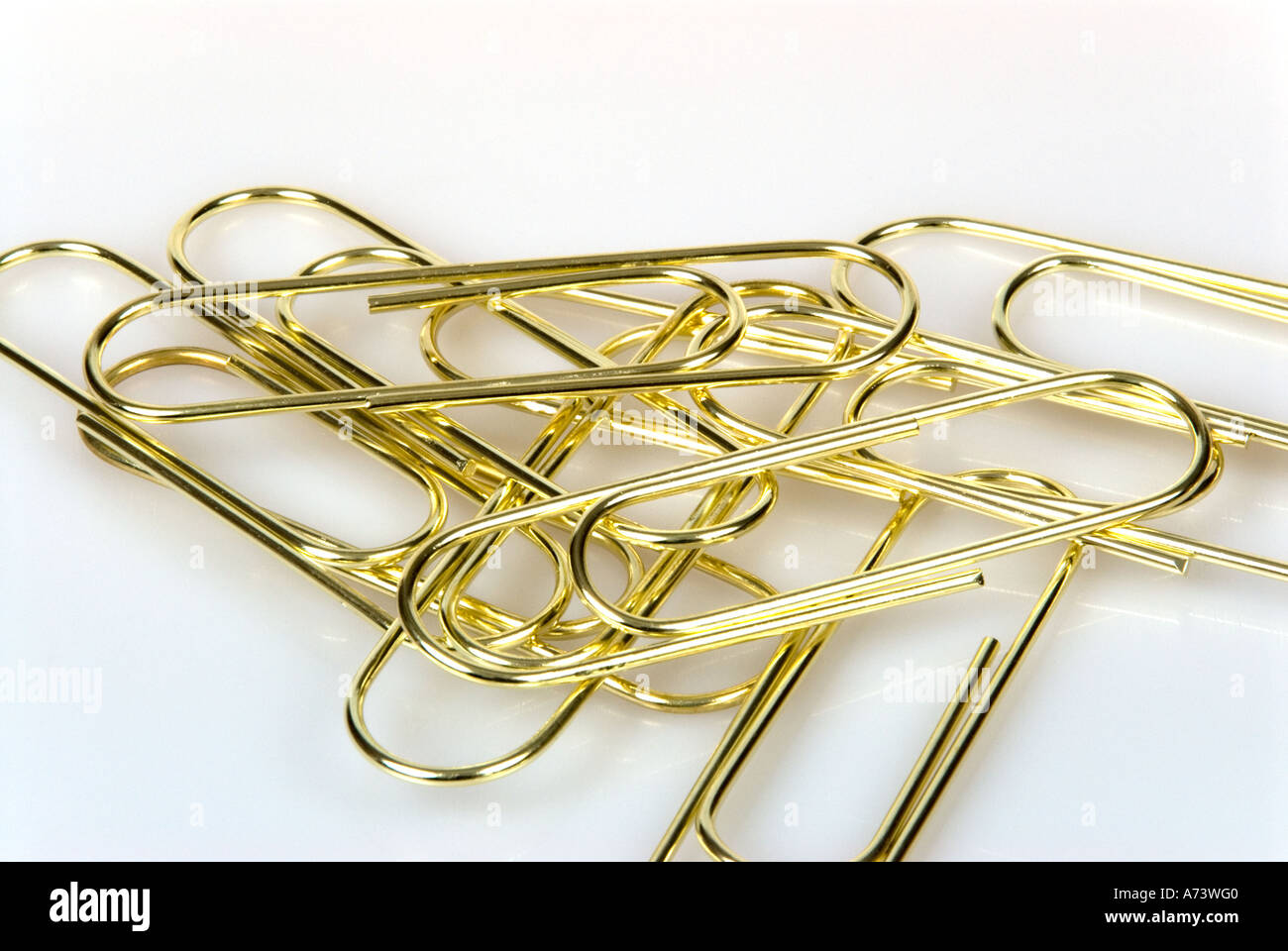 Brass paper clips against a white background Stock Photo - Alamy