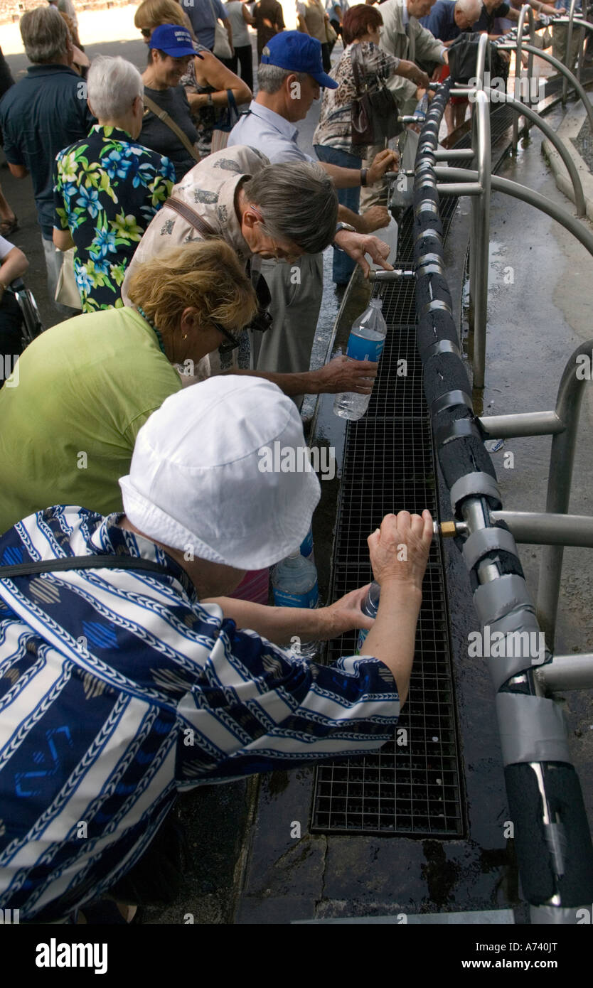 Pilgrims in Lourdes France drinking holy water Stock Photo - Alamy