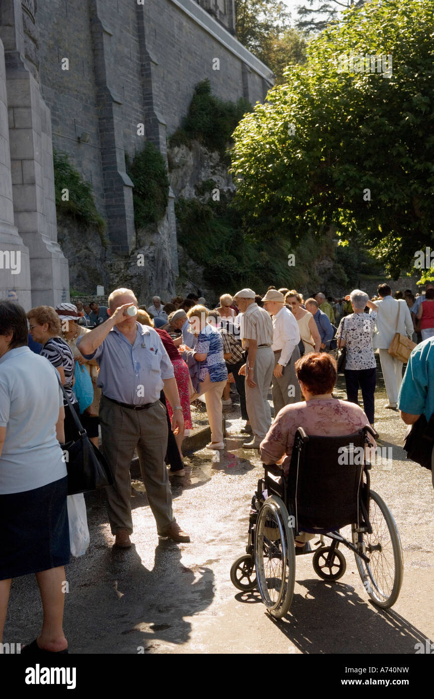 Pilgrims in Lourdes France drinking holy water Stock Photo - Alamy