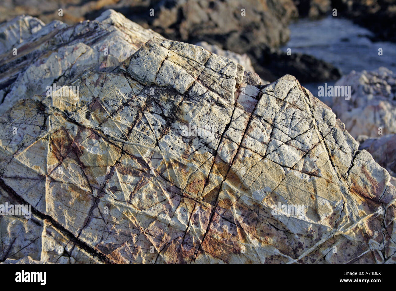 Multi layered multi coloured rock criss crossed by fracture lines near ... Multi layered multi coloured rock criss crossed by fracture lines near ...