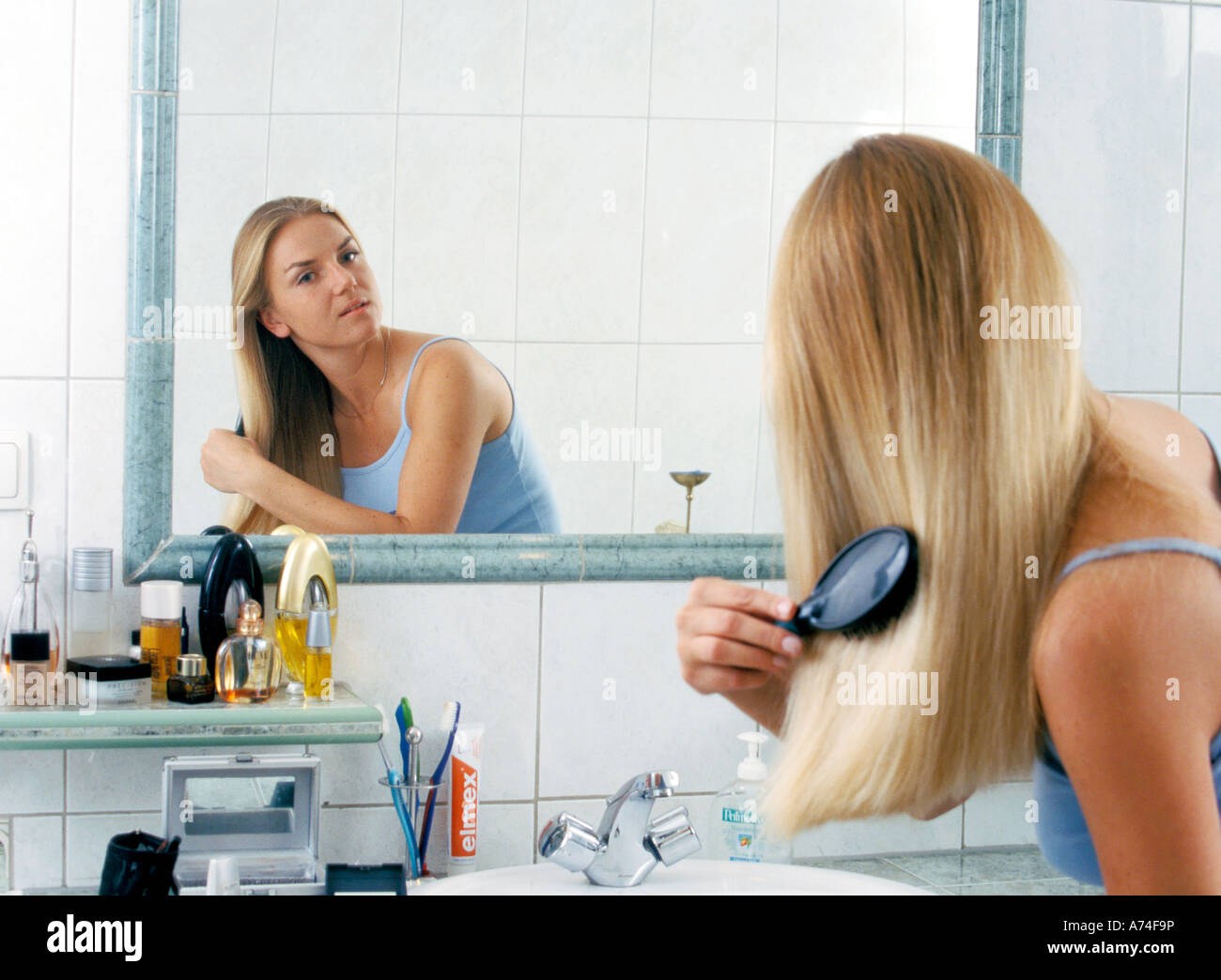 Woman in bathroom doing hair Stock Photo - Alamy