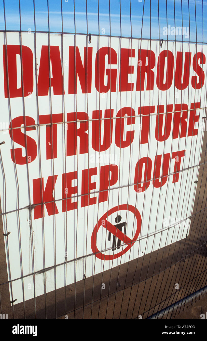 White sign behind wire mesh barrier with symbol banning people and ...