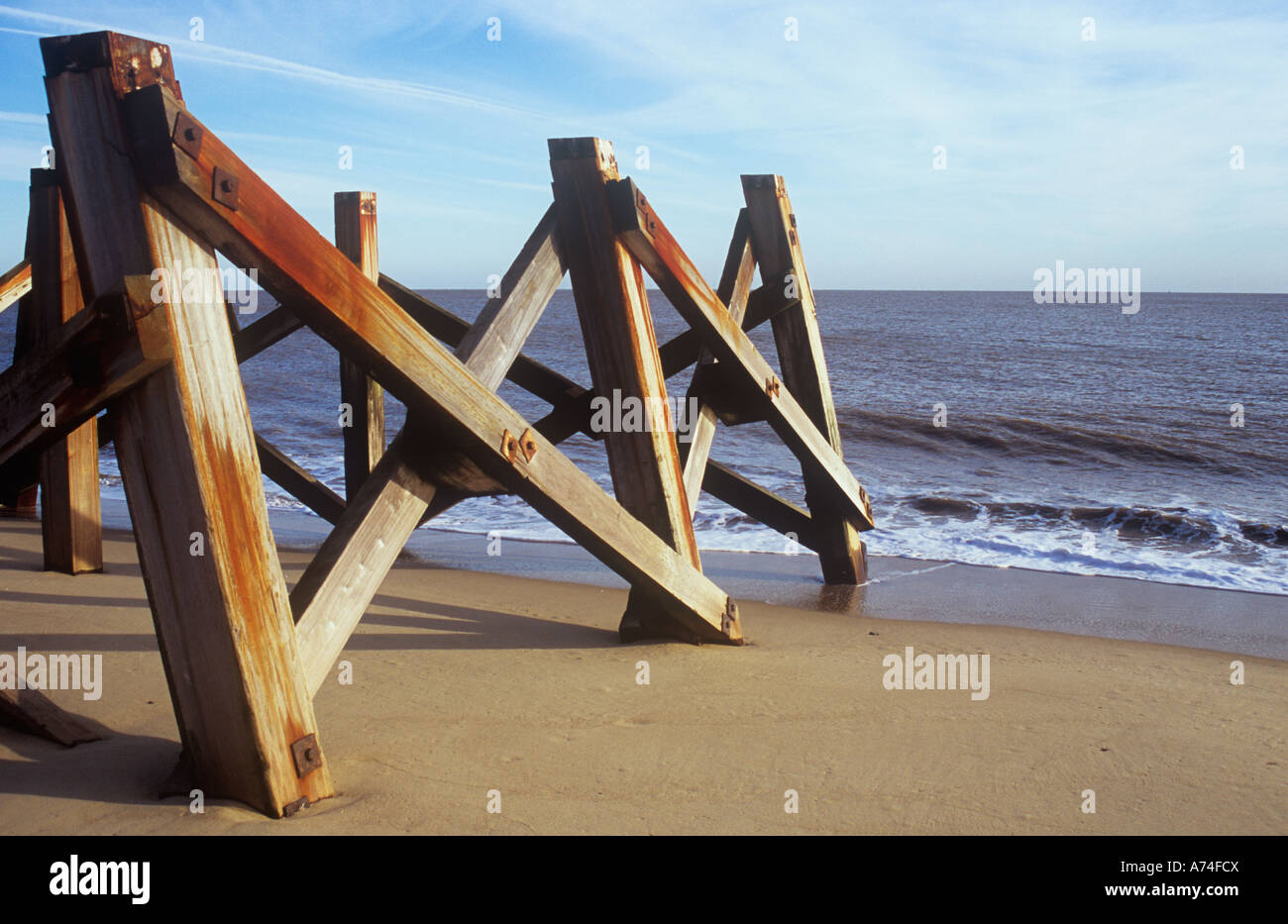 Weathered and rust–stained remains of heavy timber supports for pier or ...