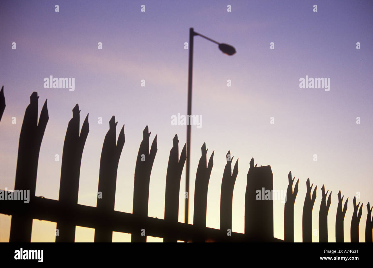 Detail of metal security railings topped with angled spikes with tall ...