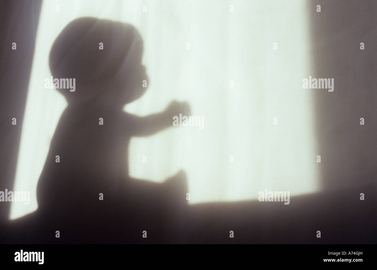 Shadow in warm light on pale cloth or curtain of traditional baby doll ...