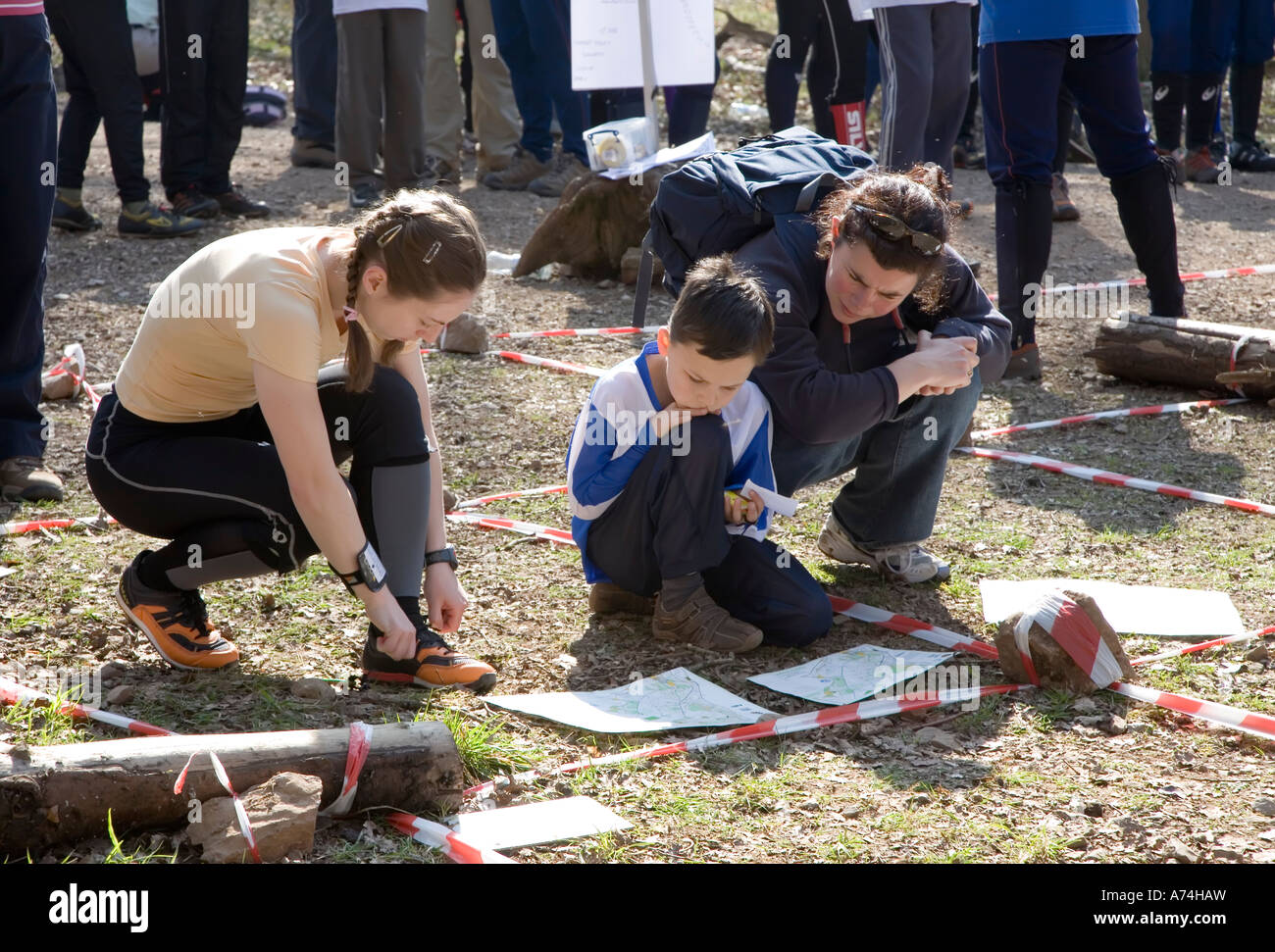 Young and old people studying maps at the start line for an ...