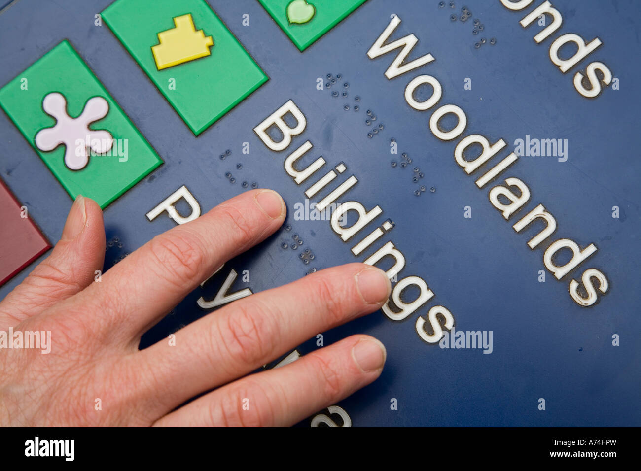 Hand reading braille on public information sign St Fagans Wales UK ...