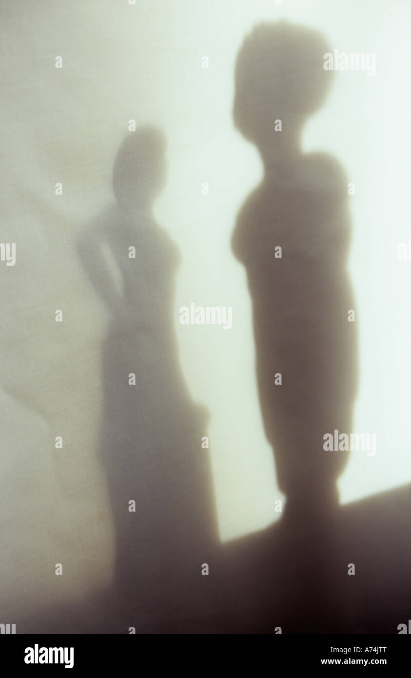 Shadow in warm light on pale cloth or curtain of two model women ...