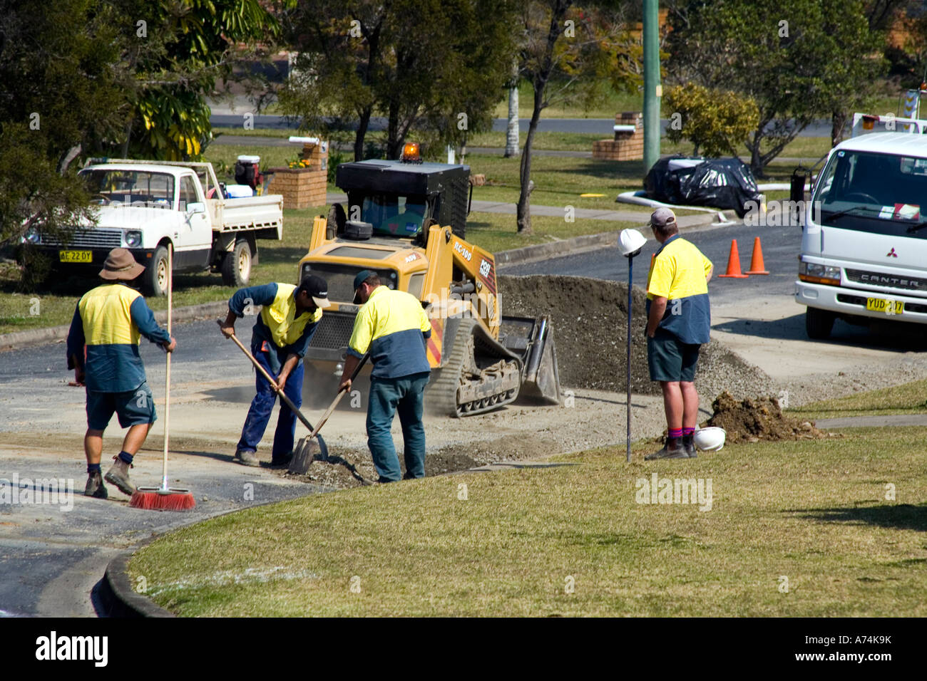 workers and machinery repairing a road Stock Photo - Alamy