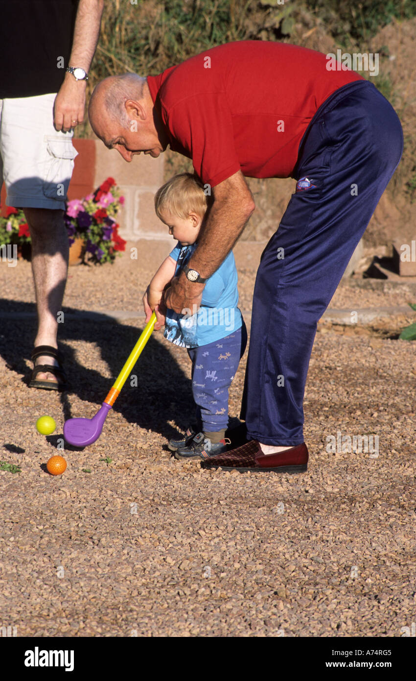 GRAND FATHER SENIOR INSTRUCTING CHILD GOLF CLUB Stock Photo - Alamy
