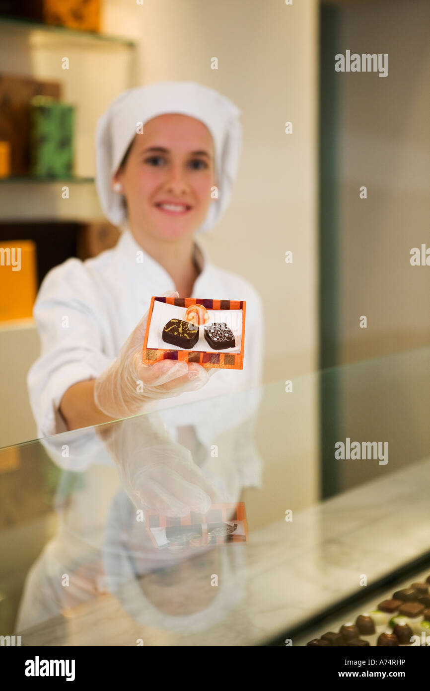 Baker displaying merchandise in candy store Stock Photo - Alamy