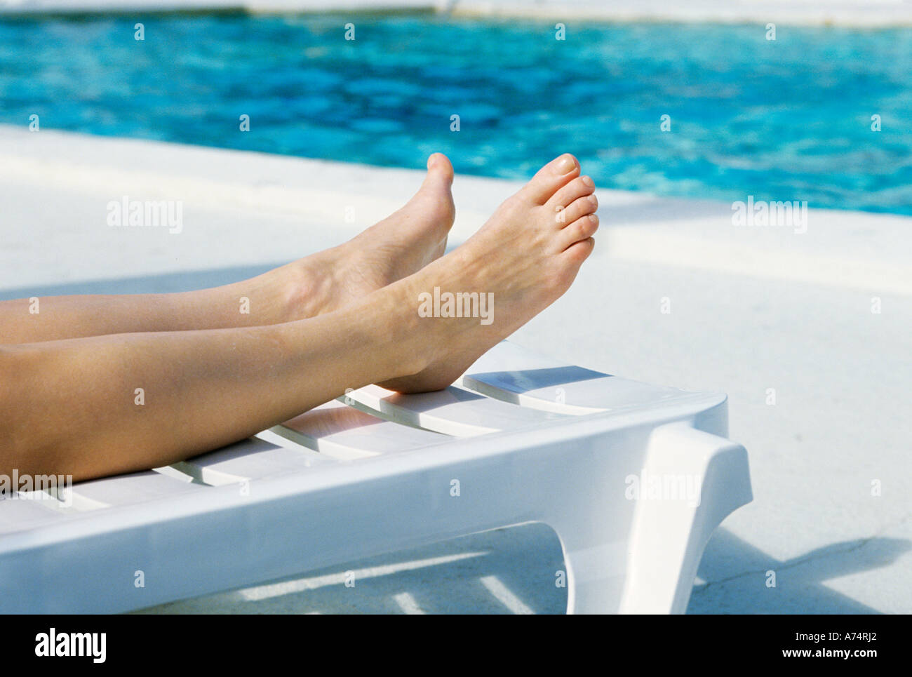 FEET ON LOUNGE CHAIR, POOLSIDE Stock Photo - Alamy